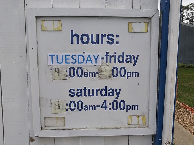 The slightly weathered hours sign tells you when to plan your treasure hunt&mdash;a humble herald for the adventures waiting inside.