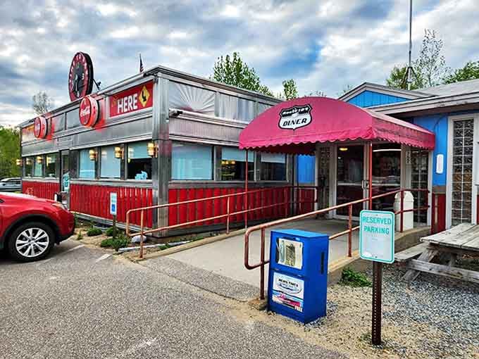 The 104 Diner gleams like a chrome time machine, its classic red trim and vintage clock sign promising comfort food that transcends decades.