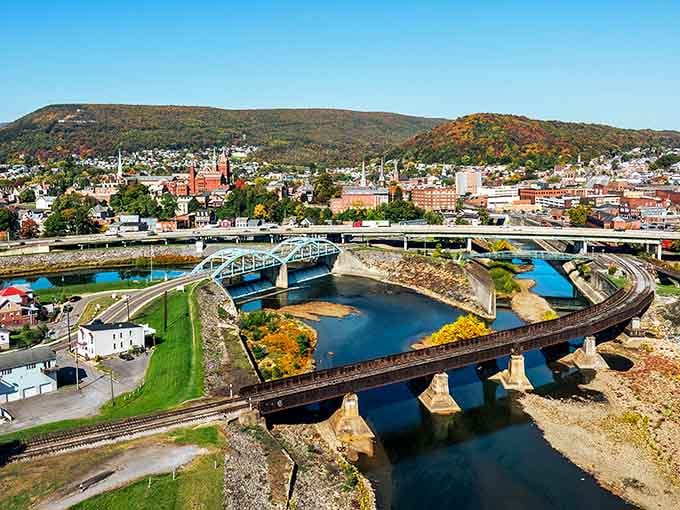 Mountains embrace this river town where bridges curve like ribbons connecting past to present in spectacular autumn colors.