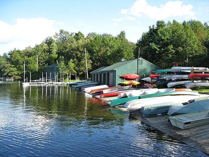 Colorful canoes line the shore like a rainbow waiting to float, promising adventures on the peaceful mountain lake.