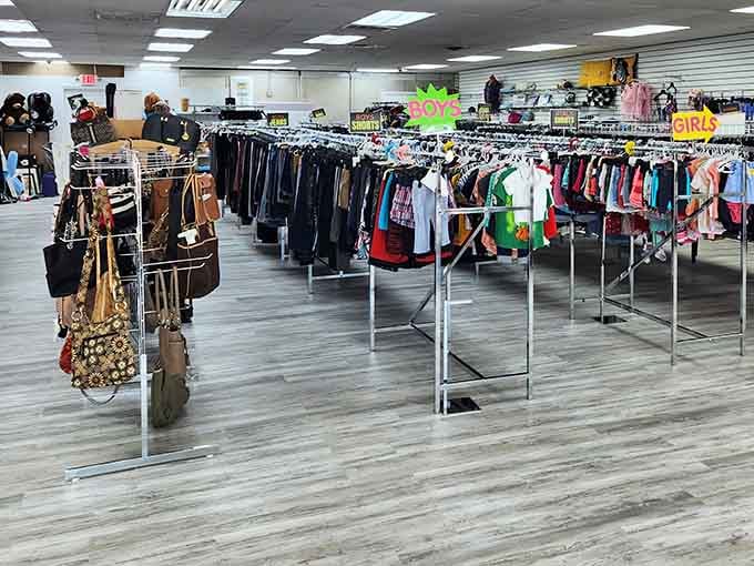 Organized clothing racks create a rainbow pathway through this massive space where fashion finds new life and purpose.