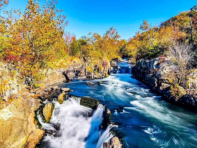 Fall colors explode around this rushing gorge, where turquoise water churns through ancient rock formations like liquid sapphire.