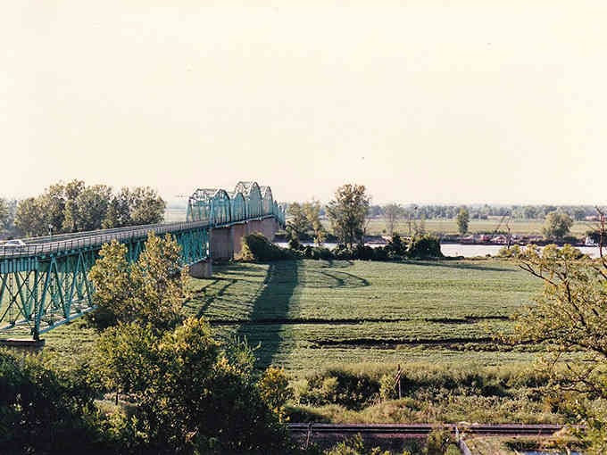 The old bridge stretches across peaceful farmland, connecting communities the way good infrastructure has done for over a century.