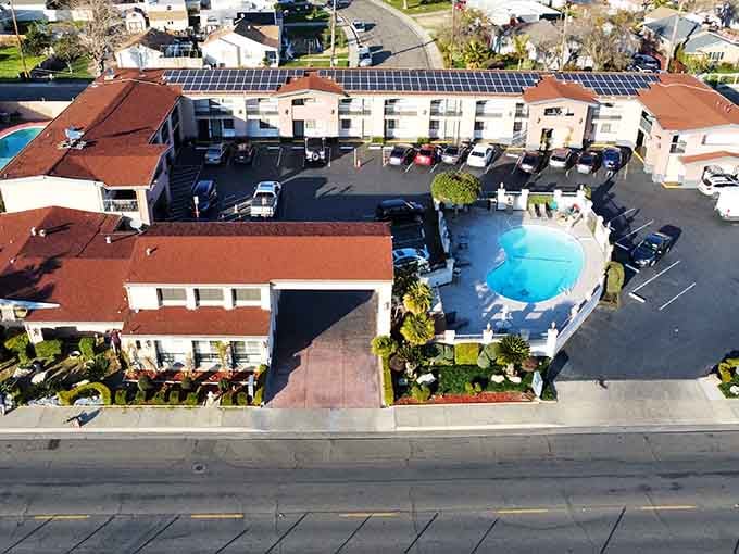 An aerial view reveals a courtyard pool surrounded by red-tiled roofs, classic California living at its finest.