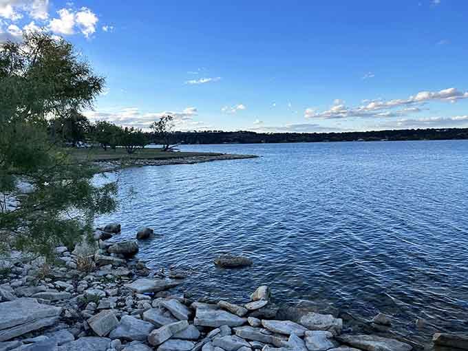 Deep blue water stretches toward distant shores where rocky outcrops meet sky in perfect harmony.