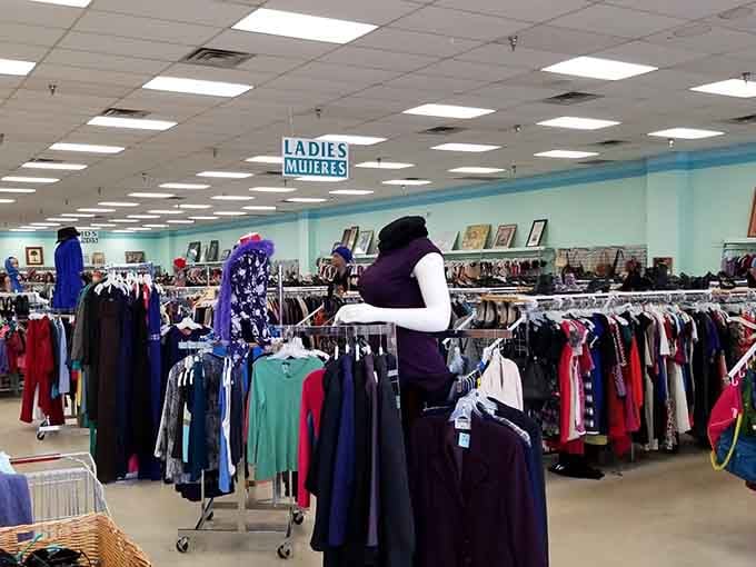 That turquoise accent wall adds unexpected charm to a space filled with endless possibilities and rainbow-colored clothing racks.