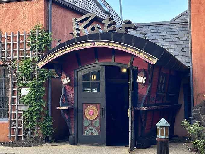 This whimsical entrance with its curved archway looks like stepping through a portal into a storybook garden.