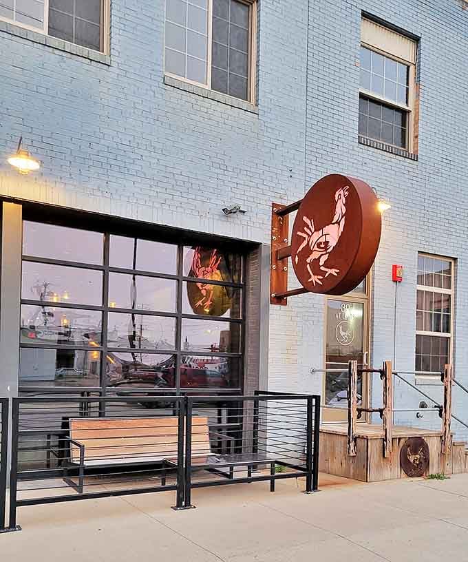 That glowing rooster sign at dusk looks like something from a Wes Anderson film, quirky and wonderful.