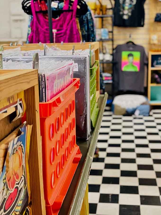 Vibrant vinyl sleeves pop against that checkerboard floor, creating a visual rhythm that matches the music waiting inside those grooves.