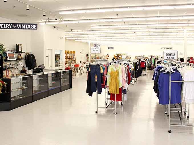 Bright white floors and organized displays create a boutique atmosphere that elevates the thrifting experience beautifully.