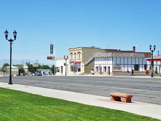 Manicured green lawn borders wide Main Street, proving small towns still care about curb appeal and community standards.