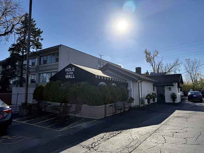 Morning light hits this cozy white building like a spotlight, revealing where locals gather for meals that feel like home.