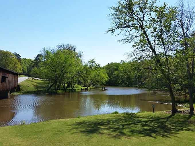 A peaceful pond reflects trees and sky while that rustic barn adds charm from another century.