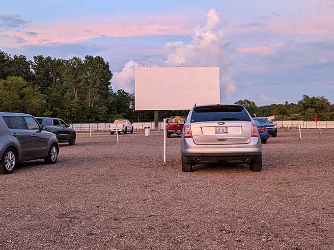 That pink and purple sunset creates the perfect backdrop for an evening of classic drive-in entertainment ahead.