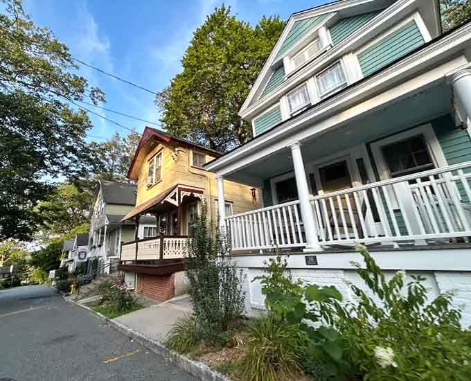 Pastel porches and climbing vines create a neighborhood where every home tells its own colorful story to passersby.
