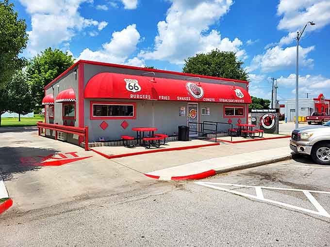 The cheerful red-trimmed exterior of Sid's promises onion burgers worth pulling over for on your Route 66 adventure.