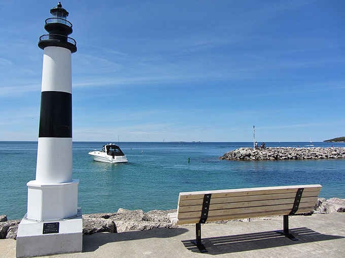 That striped lighthouse stands sentinel over turquoise waters so clear you'd swear someone Photoshopped the whole gorgeous scene.