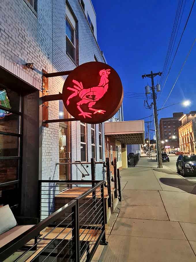 When the neon rooster lights up pink against blue twilight, you know good food is just steps away.