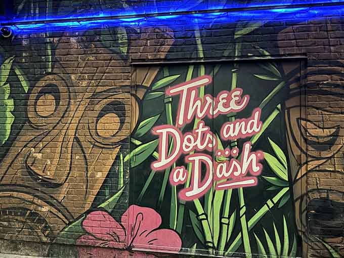 Blue neon lighting transforms the alleyway mural into a glowing invitation to paradise and exotic cocktails within.