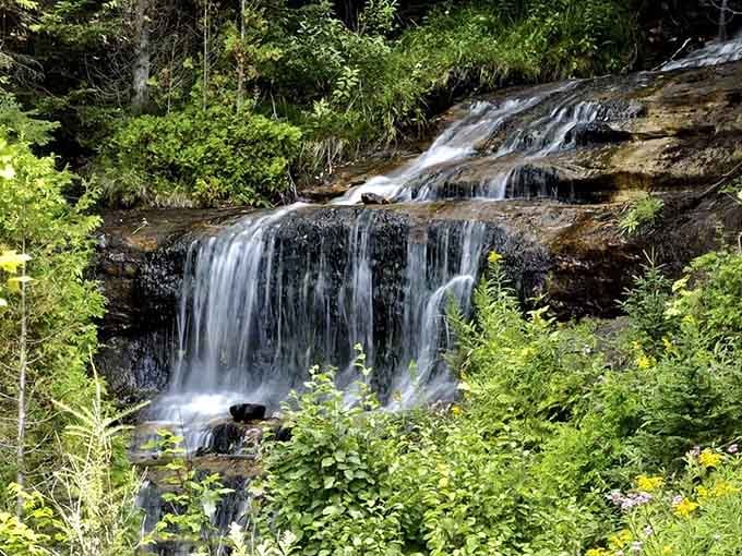 Water flows over ancient rock in graceful sheets, creating a scene so peaceful you'll forget your phone exists.
