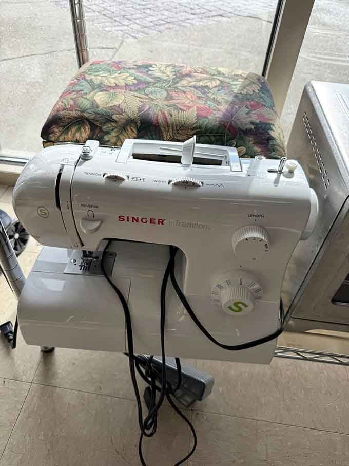 A Singer sewing machine sits ready to mend, create, or launch your long-delayed quilting dreams into reality.