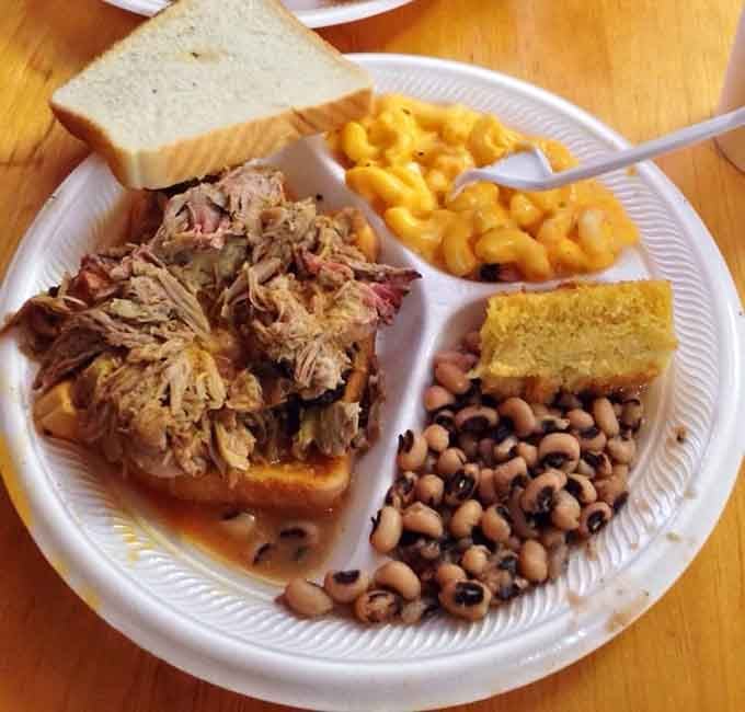 Pulled pork piled high on white bread with beans and cornbread, because carbs are just vehicles for barbecue happiness.