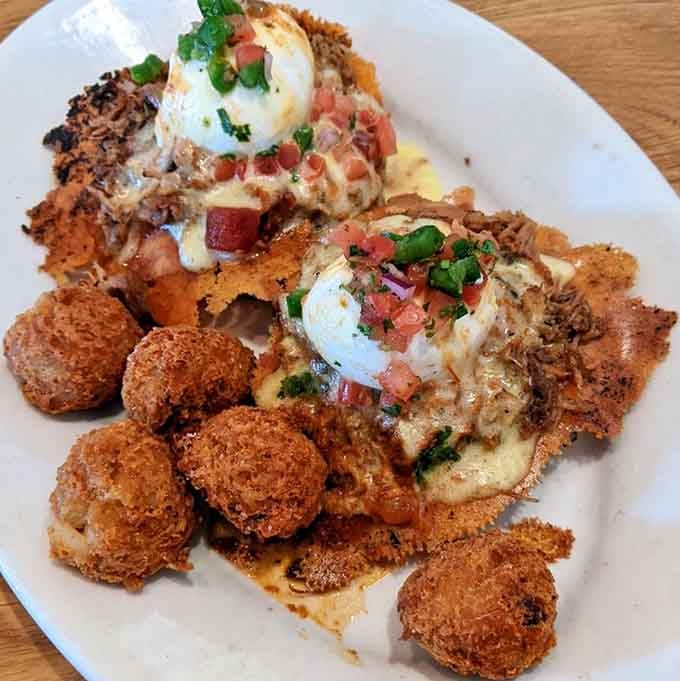 Carnitas Benedict with bacon tots proves that sometimes more is more, and apologies are completely unnecessary here.