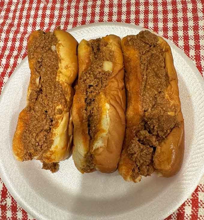 Three hot dogs lined up like they're ready to solve all your problems, one delicious bite at a time.