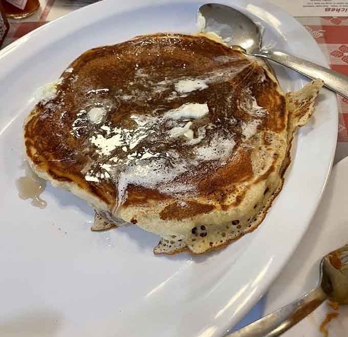 A buttermilk pancake so large it's attempting a daring escape from its plate, and we're here for it.