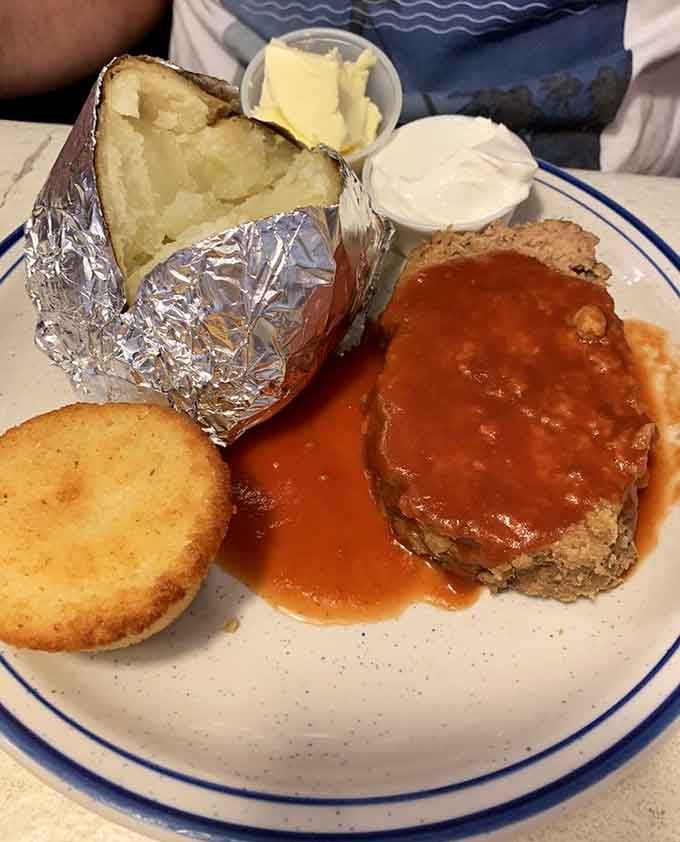 Meatloaf with a fluffy baked potato proves dinner items at breakfast spots are always worth exploring.