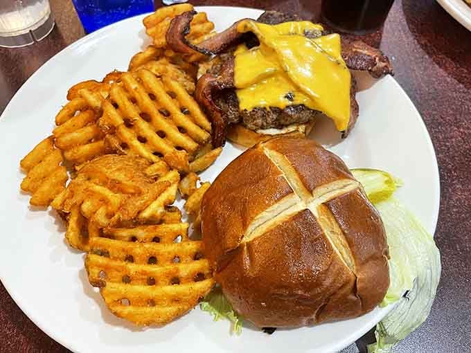 This burger with waffle fries isn't just lunch&mdash;it's edible artwork on a pretzel bun with cheese melting like a South Dakota sunset.