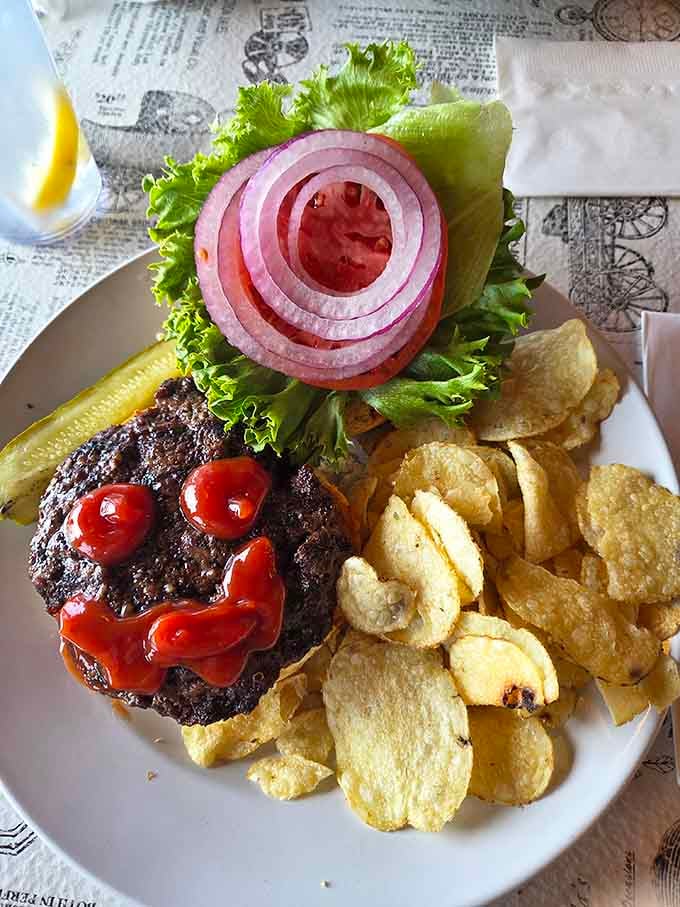 A burger topped with perfectly sliced onions and crispy chips, looking like a magazine cover come to life.