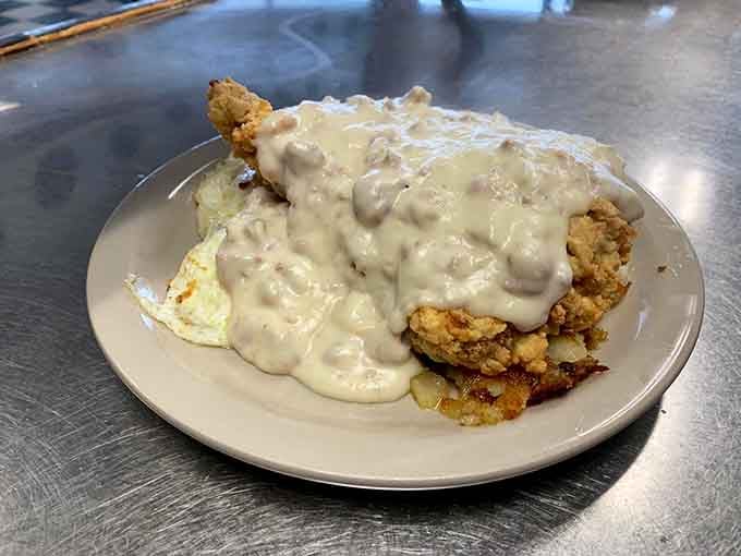 Chicken fried steak swimming in gravy &ndash; where crispy exterior meets tender interior in a pool of savory satisfaction. Diet plans surrender at first bite.