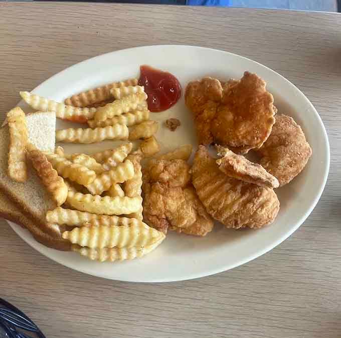 Chicken nuggets and crinkle-cut fries proving that sometimes the simplest pleasures are the most satisfying ones.