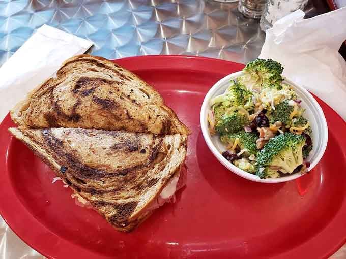A Reuben on rye with broccoli salad, proving that even classic diners understand the importance of vegetables, sort of.