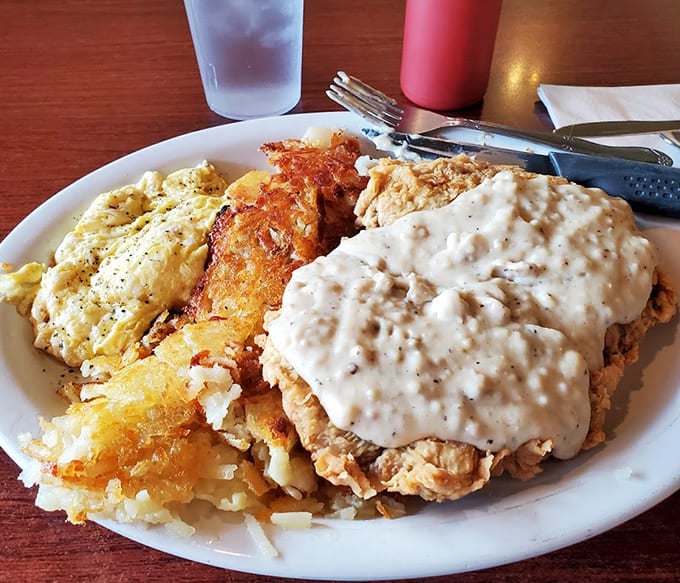 Chicken fried steak smothered in gravy next to scrambled eggs – someone here understands what breakfast means in ranch country.