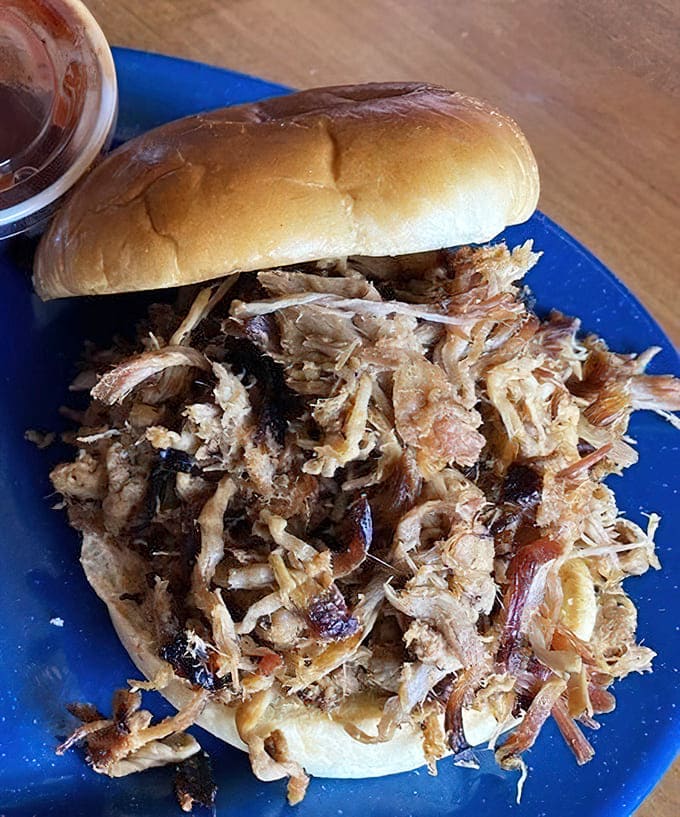 Pulled pork stacked so generously, this sandwich needs an engineering degree to eat properly without making a mess.