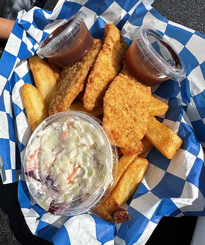 Golden fish, crispy fries, and coleslaw arrive in a basket that practically glows with fried perfection.