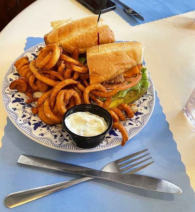 A sandwich that demands two hands and zero distractions, with curly fries that spiral into crispy perfection.