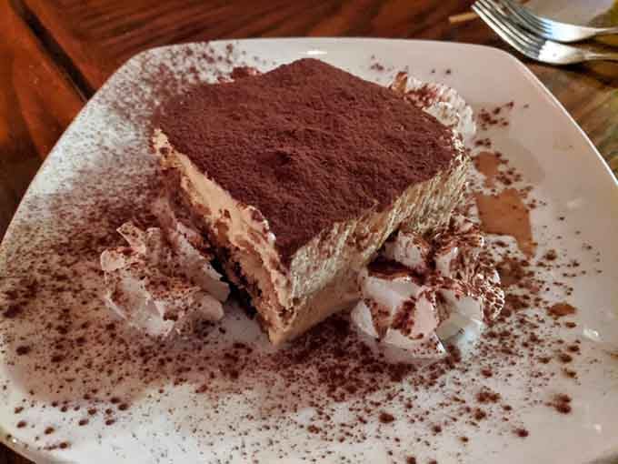 Tiramisu dusted with cocoa, layers of mascarpone cream visible. This is how you end a meal properly, friends.