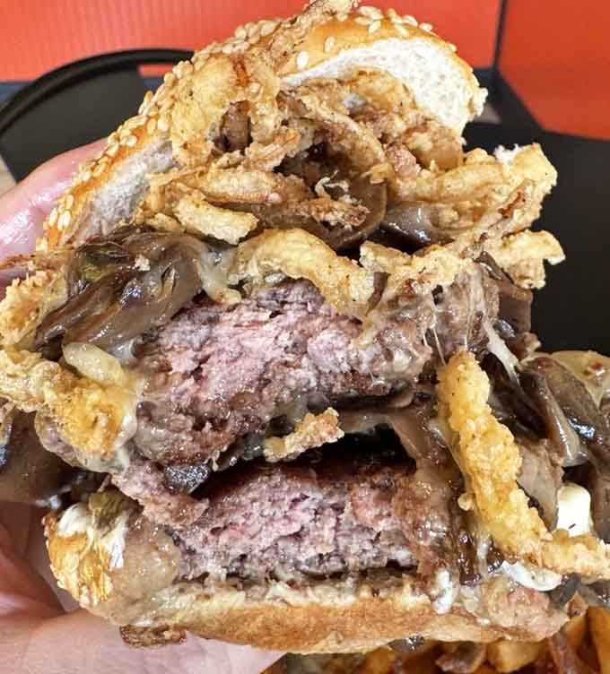 When mushrooms and onions pile this high on a burger, you know someone in that kitchen understands what "generous portions" actually means.