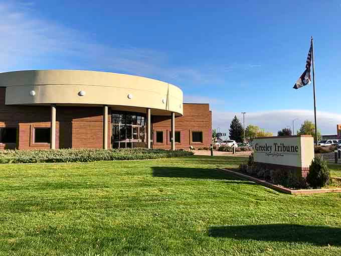 The Greeley Tribune building stands as a modern sentinel of local journalism, where community stories find their voice amid manicured lawns.