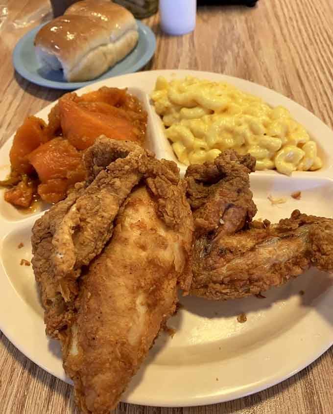 Look at that perfectly seasoned crust on the chicken breast, paired with mac and cheese and candied yams worth writing home about.