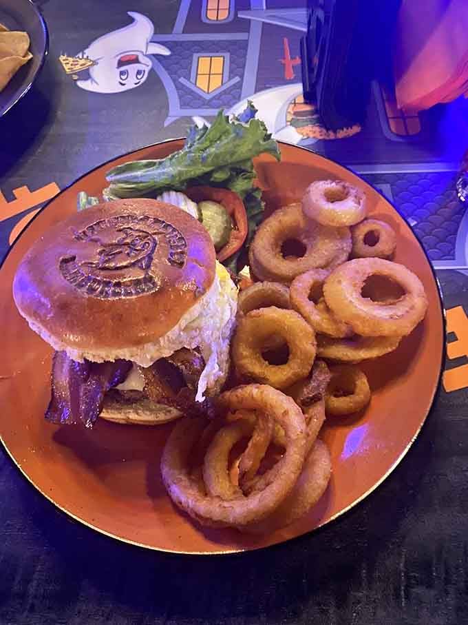 The Zombie burger arrives with onion rings and lettuce, proving that even the undead appreciate a well-balanced meal presentation.