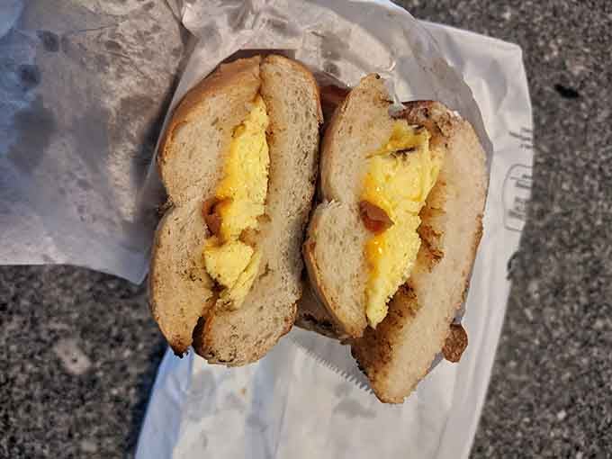 A bagel breakfast sandwich cut in half reveals its simple secret: fresh eggs and no-nonsense satisfaction.
