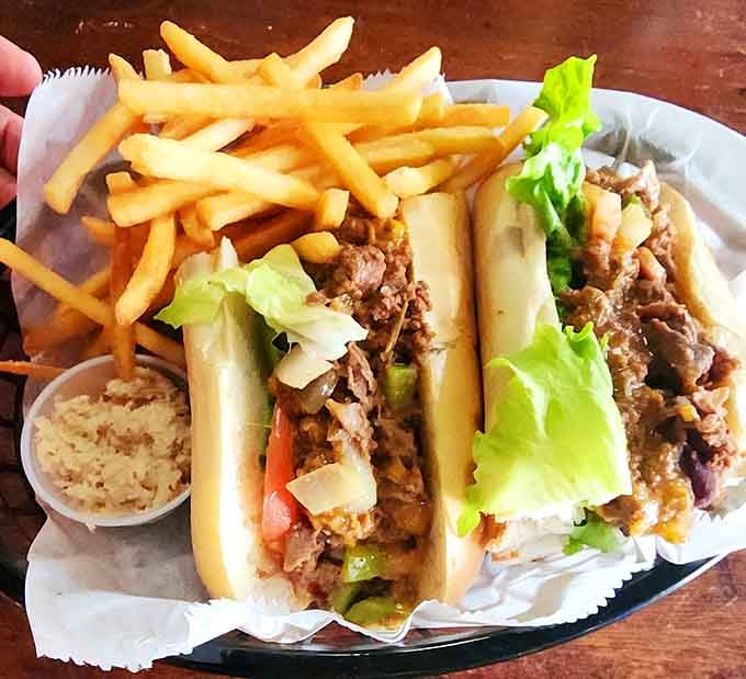 Two loaded cheesesteaks with peppers and onions spilling out, because subtlety has no place in perfection here.