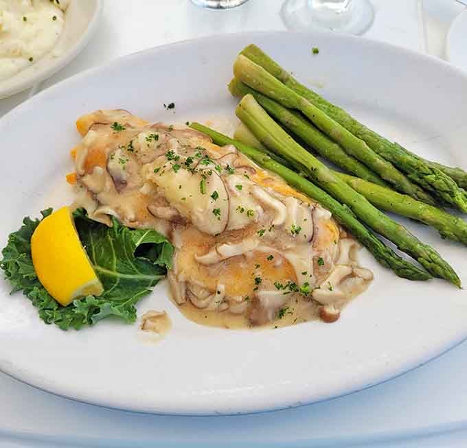 Red snapper topped with mushrooms and asparagus spears standing at attention like edible soldiers of flavor.