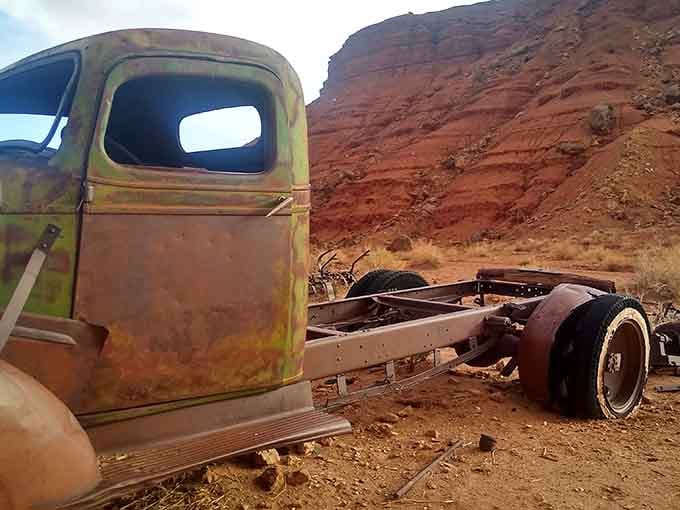 Vintage truck rusting gracefully against red rocks, looking like it drove straight out of a Steinbeck novel and stayed.