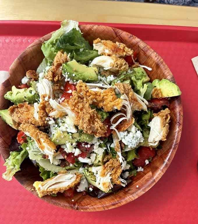 Crispy fried chicken crowning a fresh salad is the mullet of meals: business on bottom, party on top.