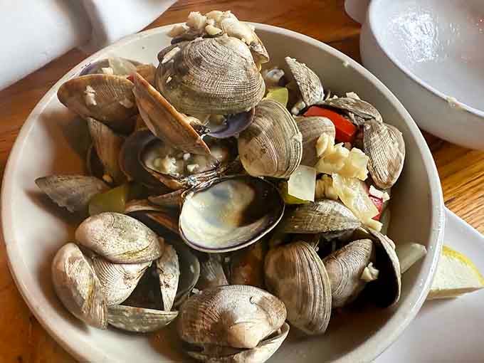 Fresh clams piled high like edible treasure, ready to deliver that sweet ocean flavor you're craving.
